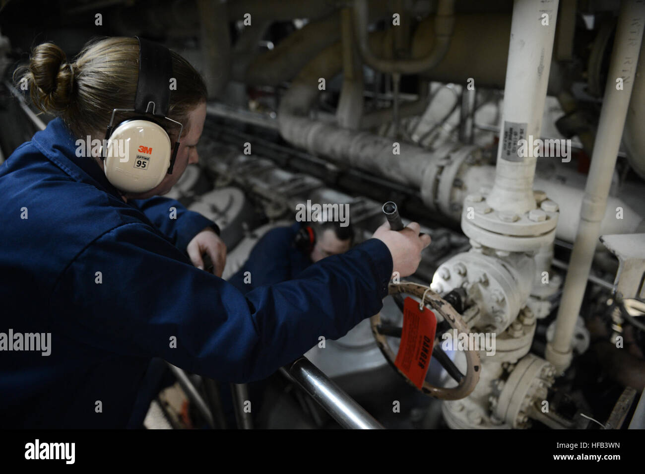 U.S. Navy Chief Engineman Melanie Israel, left, shines a light for ...