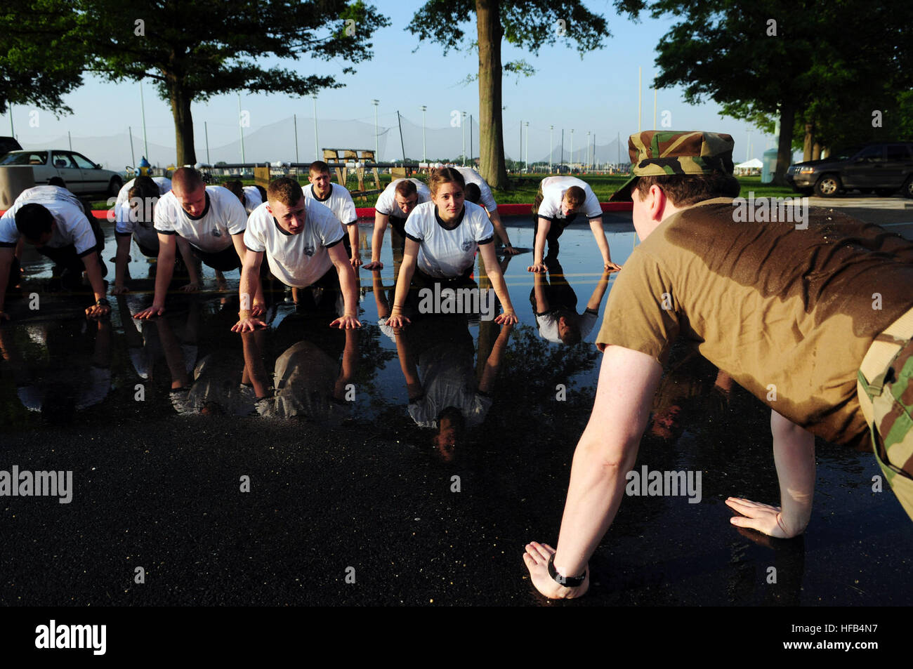 An upper-class midshipman leads Ppebes in puddle push-ups on Farragut ...