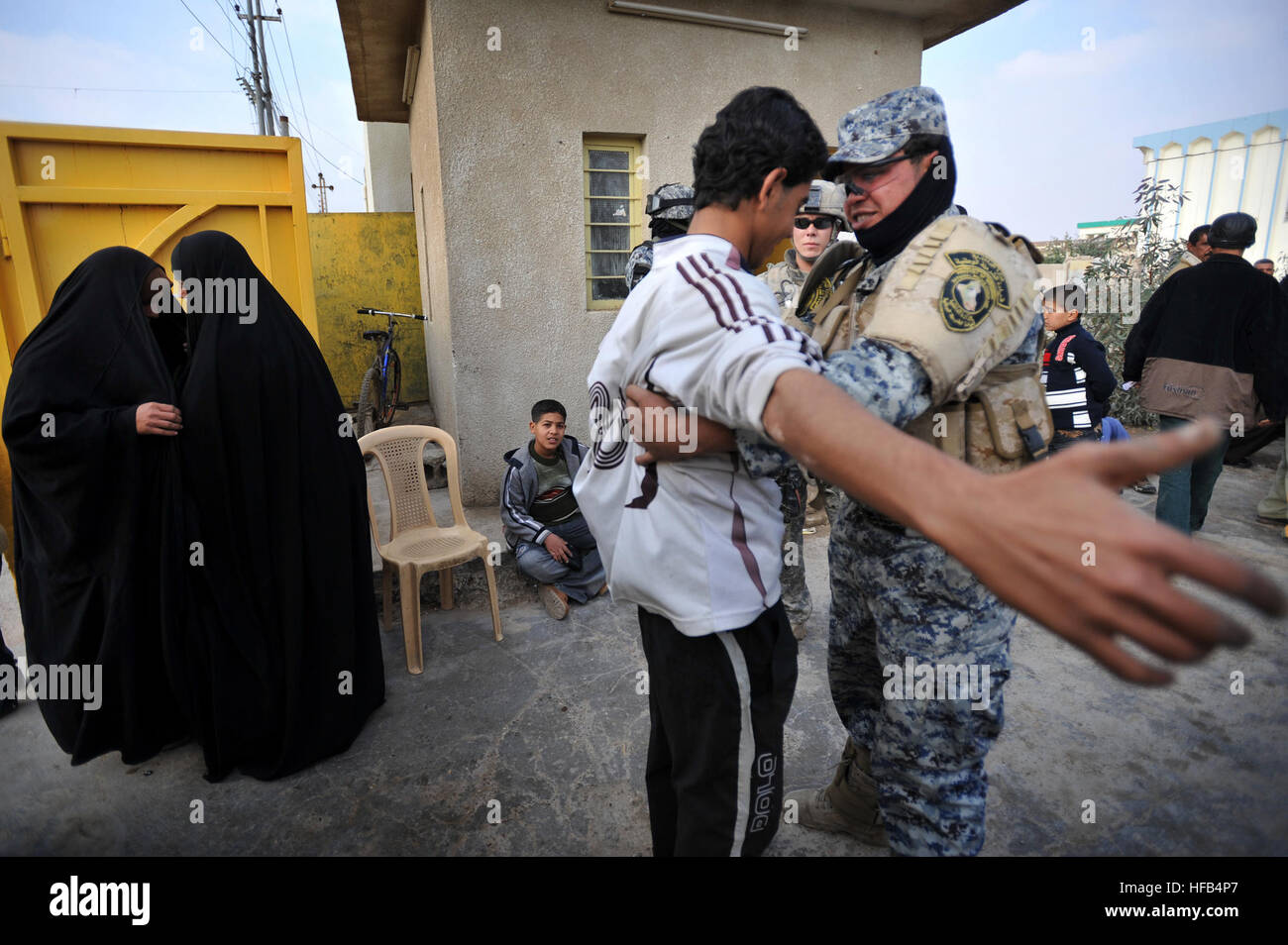 Iraqi national policemen and women check Iraqi civilians, as a security ...