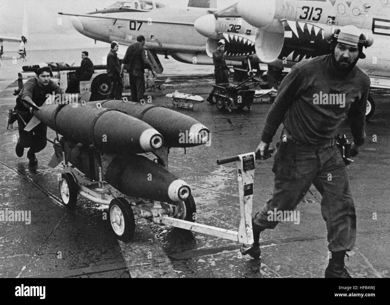 Crewmen move Mk 82 bombs on USS Midway (CV-41) flight deck c1975 Stock ...