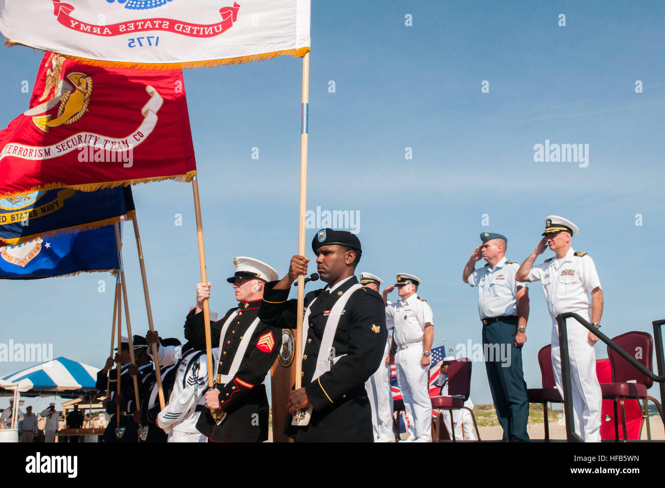 U.S. Service members present flags during a ceremony commemorating the ...