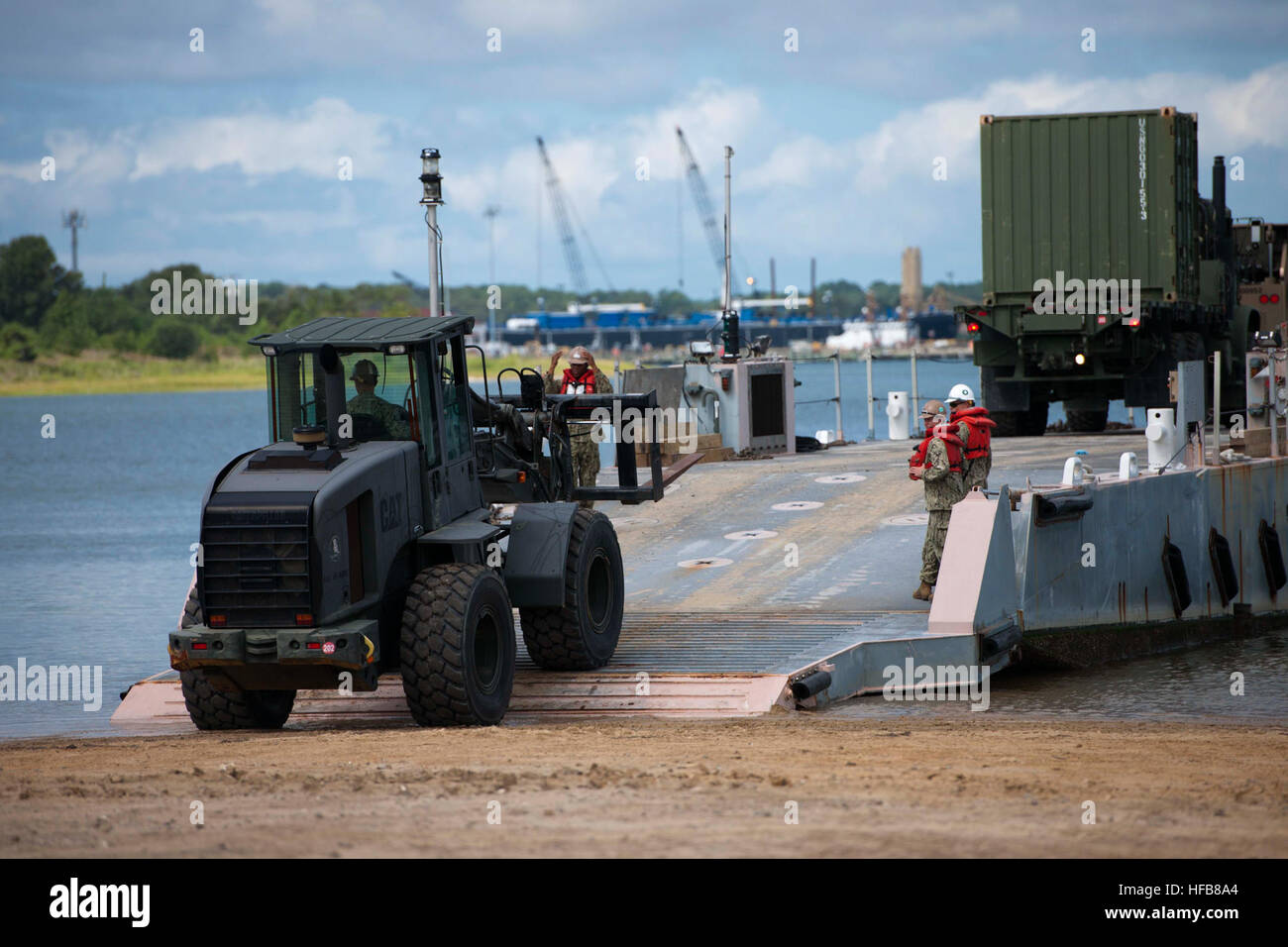Sailors unload equipment from an Improved Navy Lighterage System (INLS ...