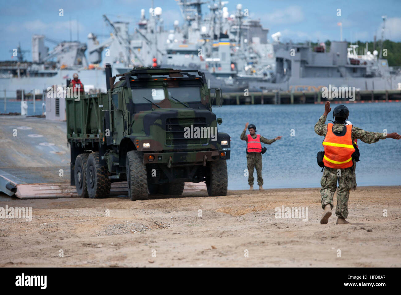 Sailors unload equipment from an Improved Navy Lighterage System (INLS ...