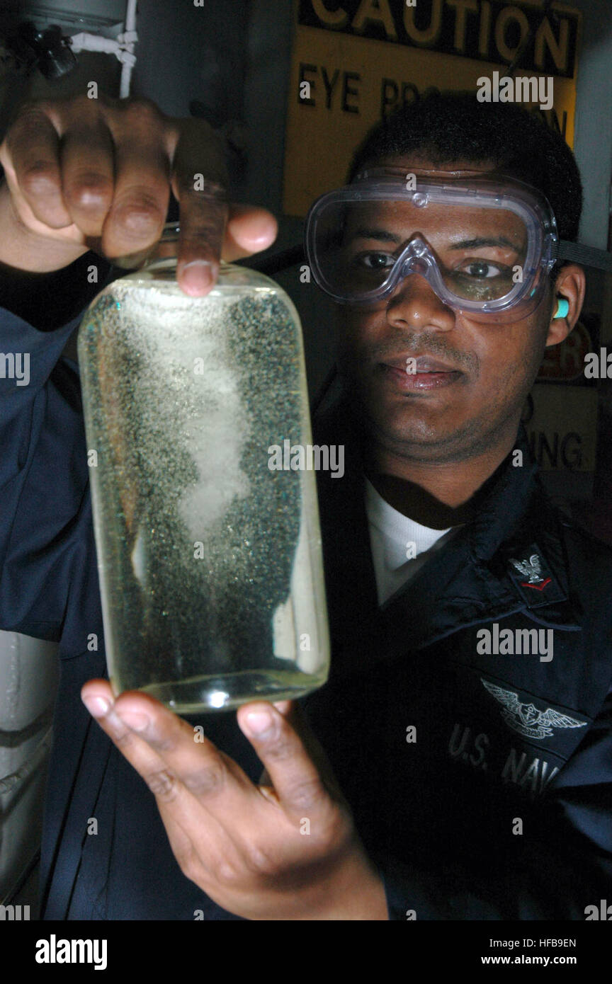 Petty Officer 3rd Class Vishal Mudi examines a JP-5 fuel sample from ...