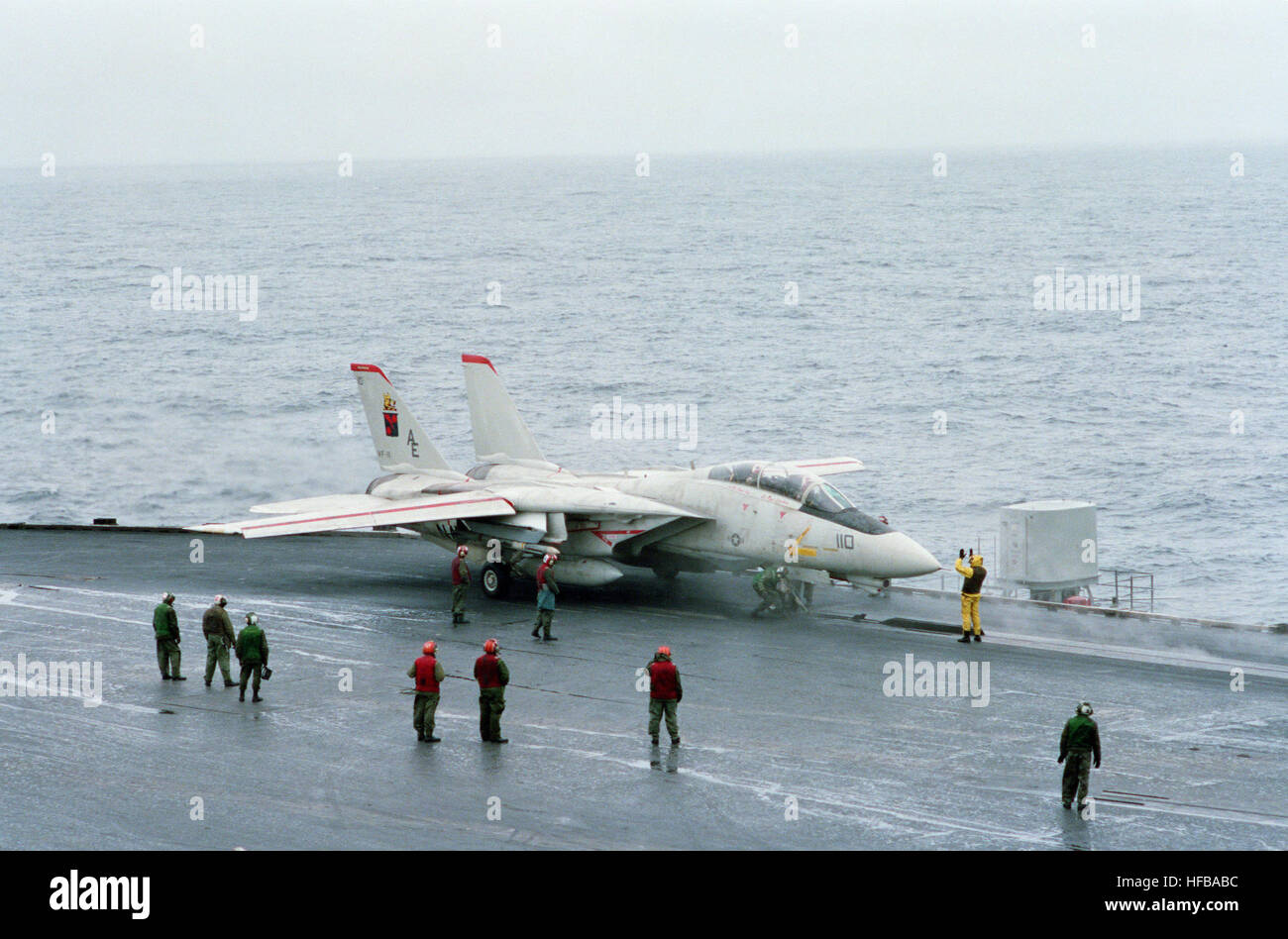 Flight deck crew members attach a Fighter Squadron 11 (VF-11) F-14A ...