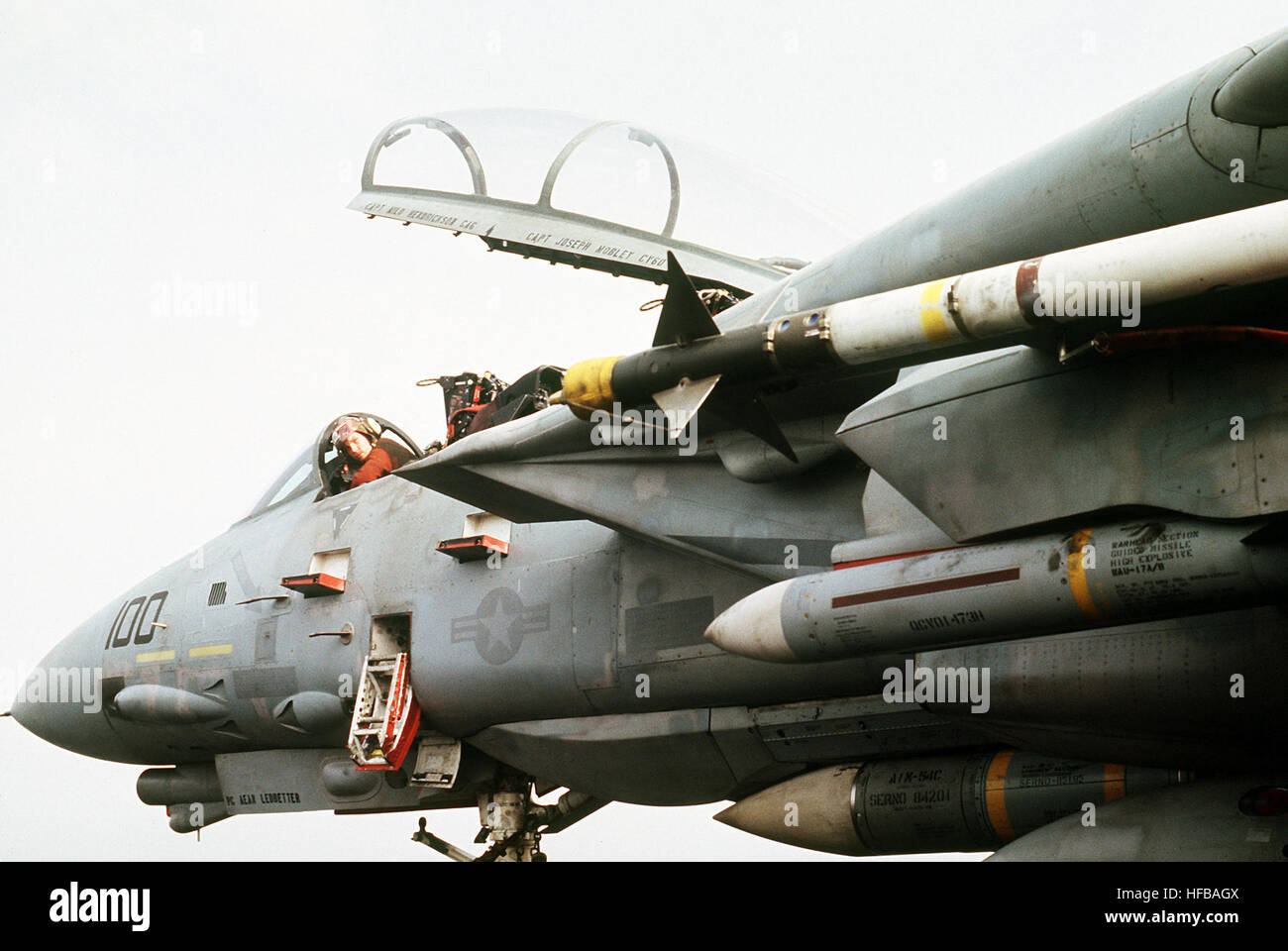 A flight deck crew member performs a preflight check on an F-14A Tomcat ...
