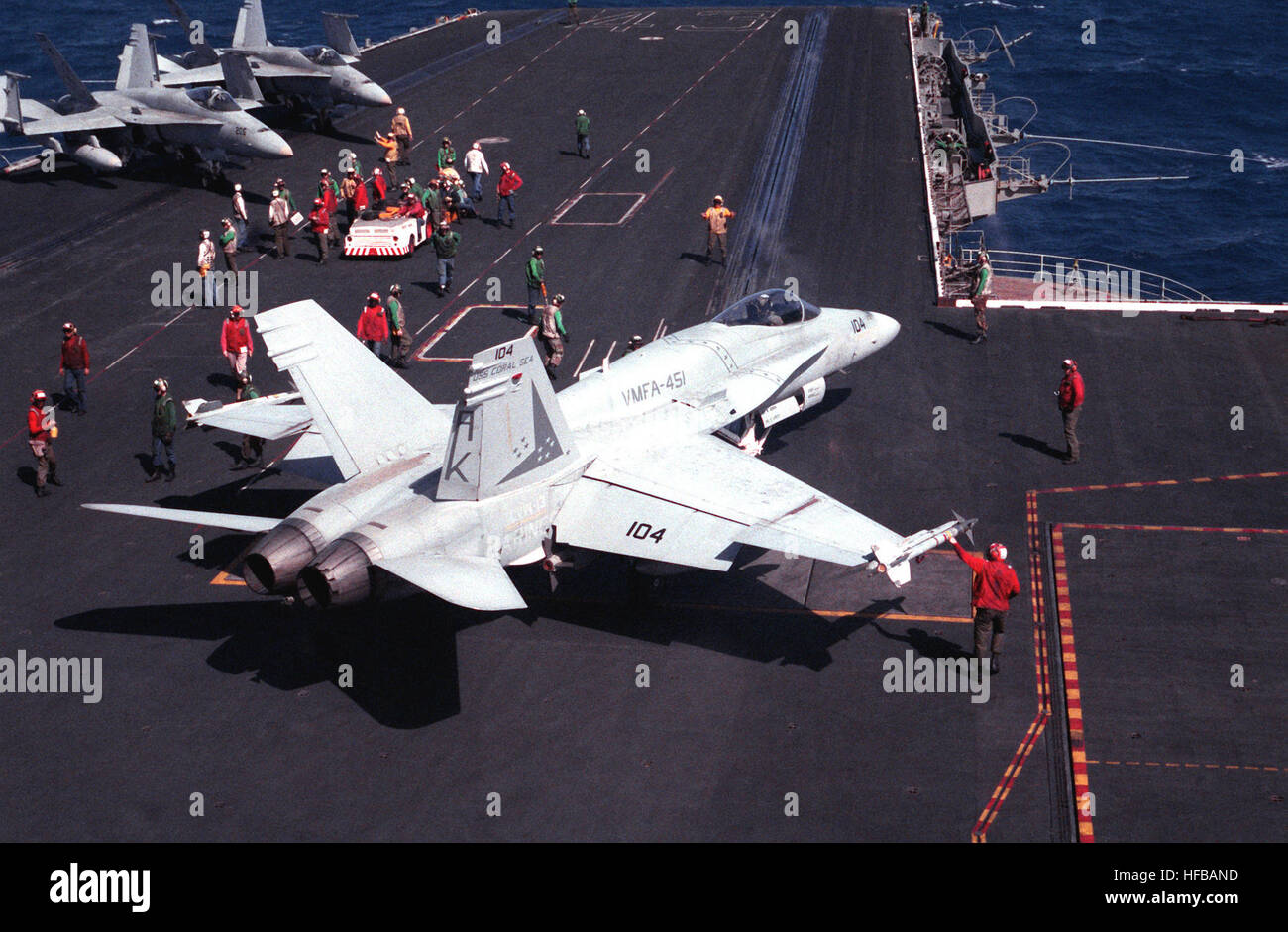 An ordnanceman checks an AIM-9 Sidewinder missile on the wing of a ...