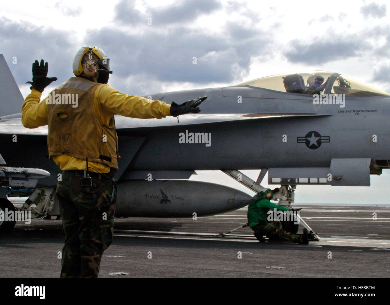A Sailor signals an F/A-18 Hornet of Strike Fighter Squadron 143, the ...