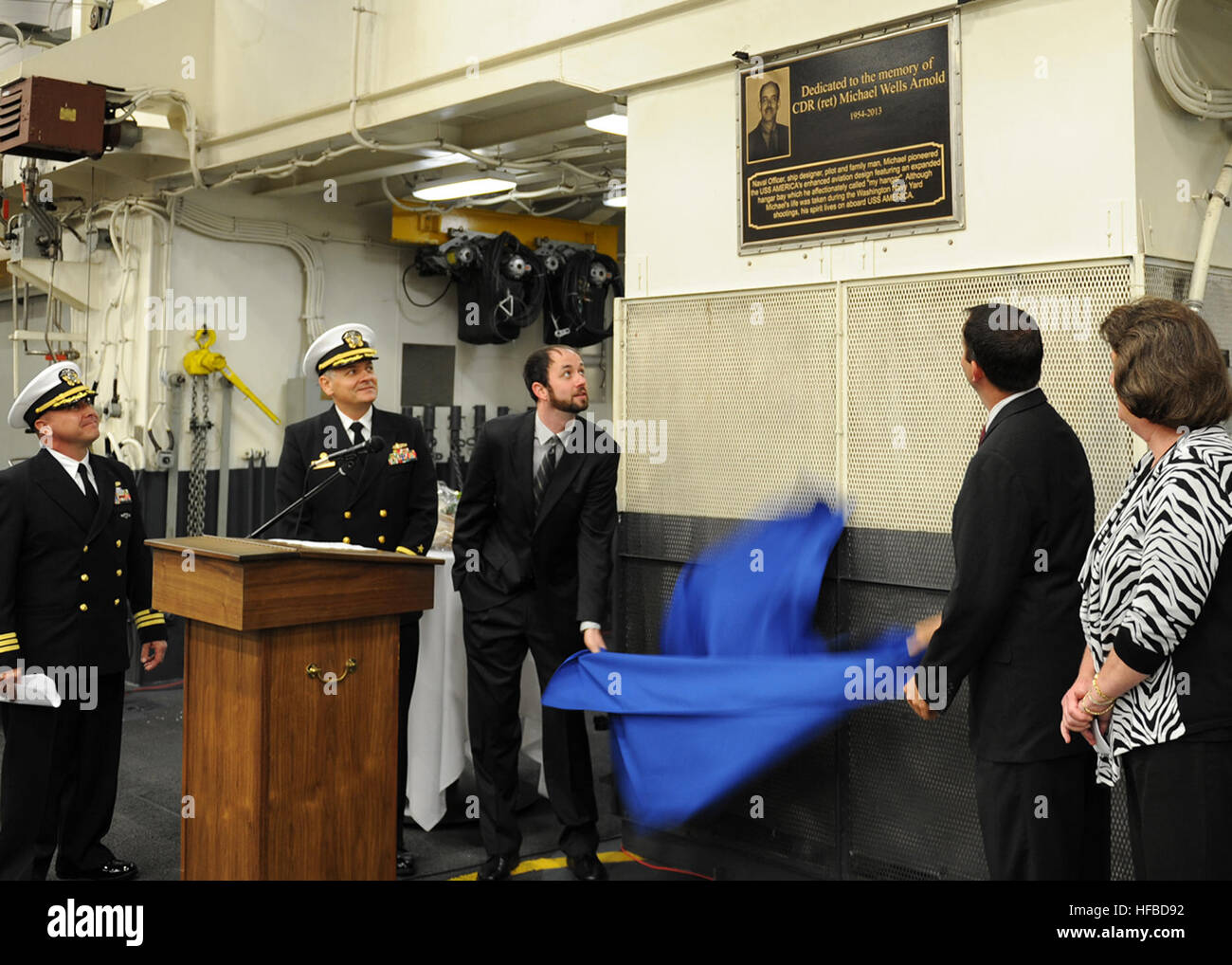 Family members of retired Cmdr. Michael W. Arnold unveil a plaque ...