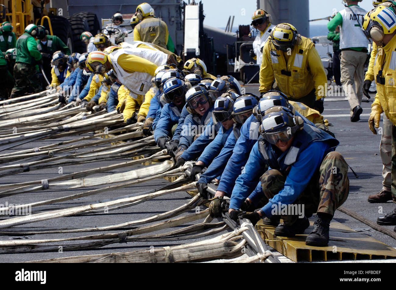 Sailors on USS Kitty Hawk (CV 63) raise an aircraft barricade during ...