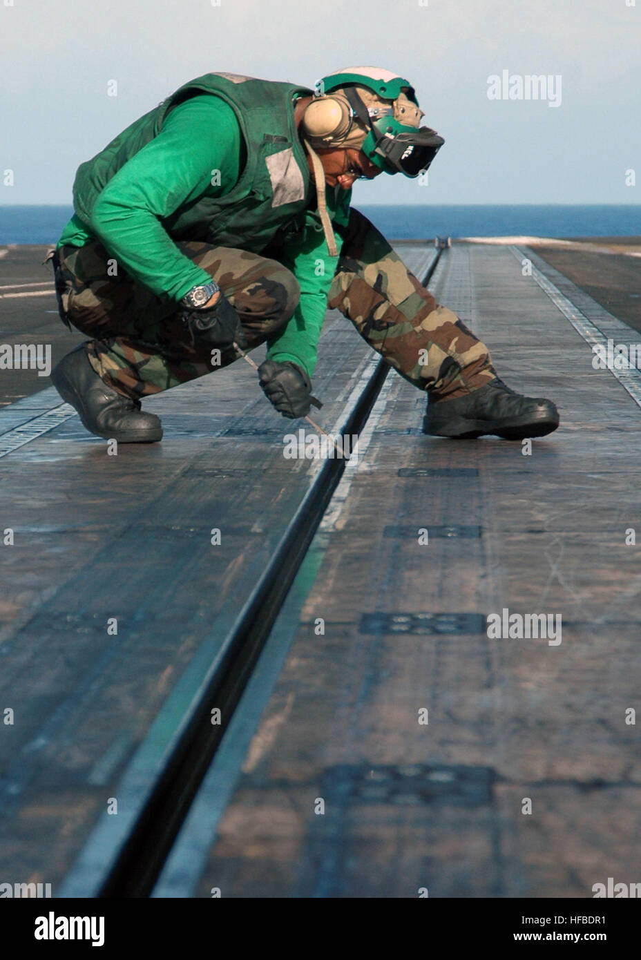Petty Officer 3rd Class Kenneth London files down burs in a catapult ...