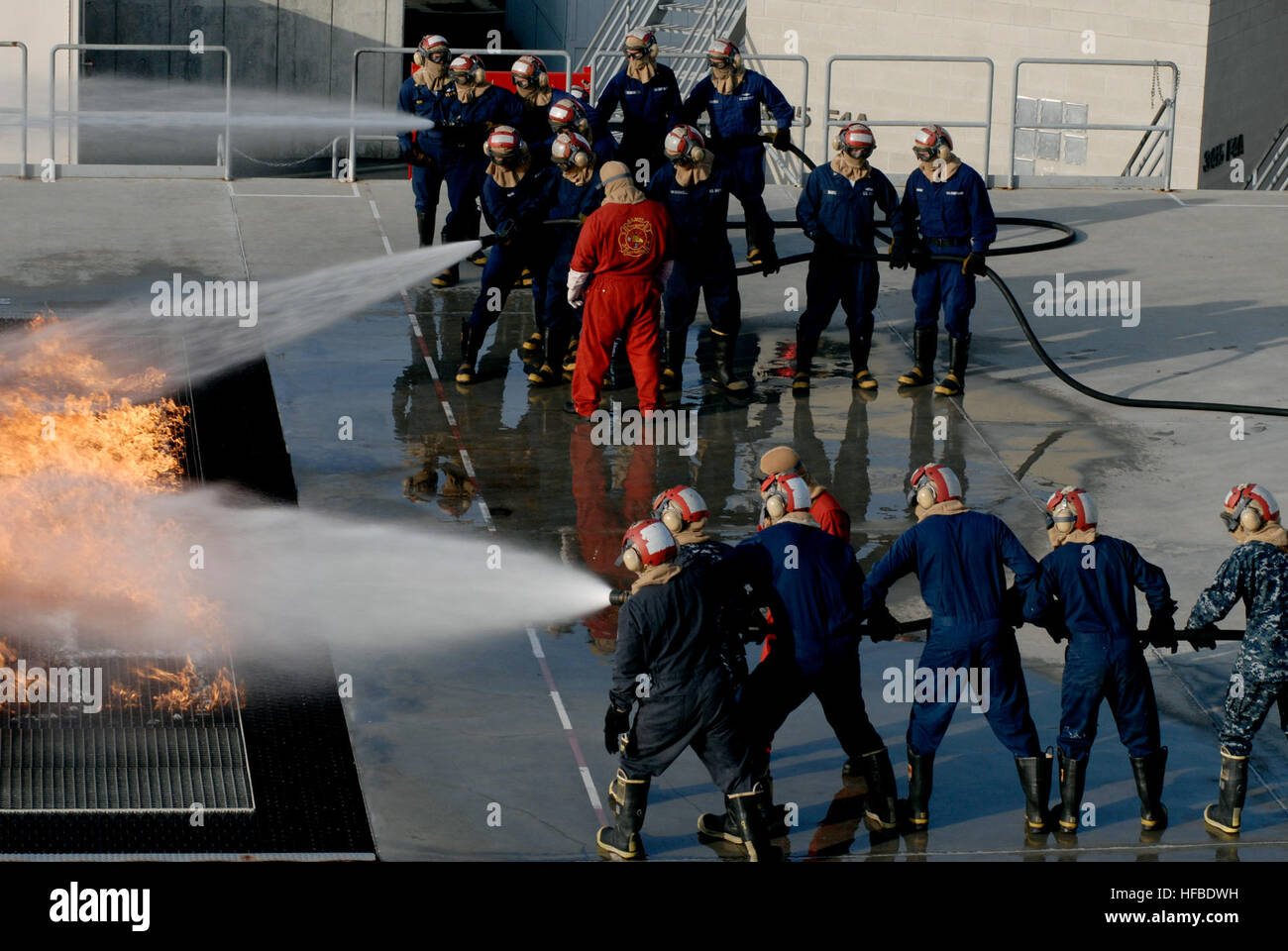Sailors and Coast Guardsmen battle a simulated flight deck fire during ...