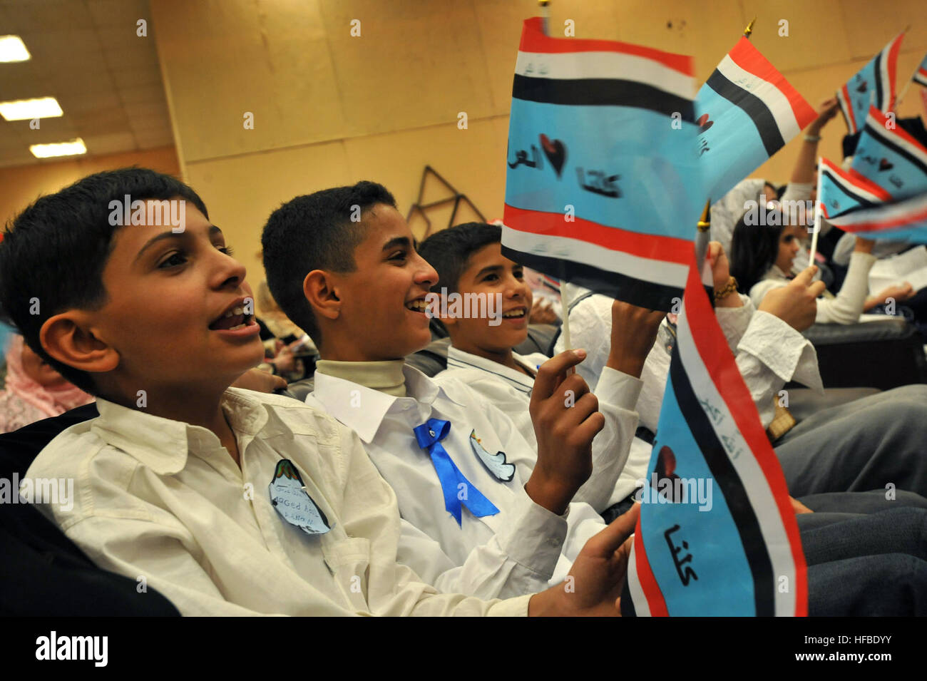 Iraqi children wave Iraqi flags and sing their national anthem within ...