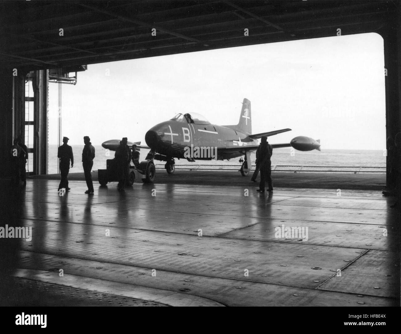 An FJ-1 Fury is positioned on the deck edge elevator of an aircraft ...