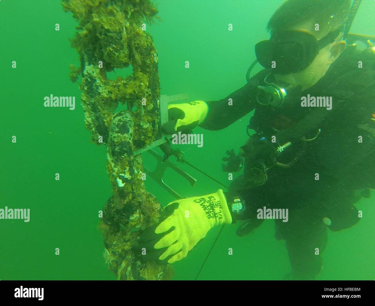 Naval personnel inspect and repair fleet mooring riser chains and buoys ...