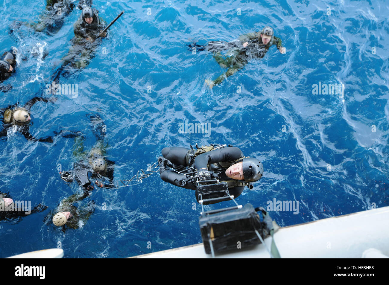 A Navy SEAL climbs a ladder attached to an offshore gas and oil ...