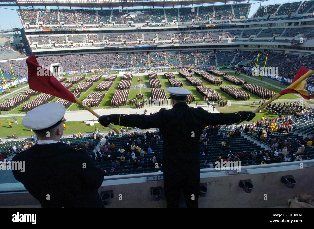 Midshipmen signal the brigade to turn and salute the opposing team ...