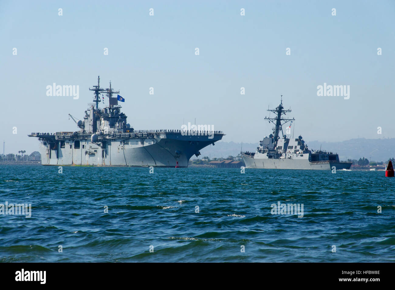 USS Essex (LHD 2), an amphibious assault ship, passes USS Stockdale ...