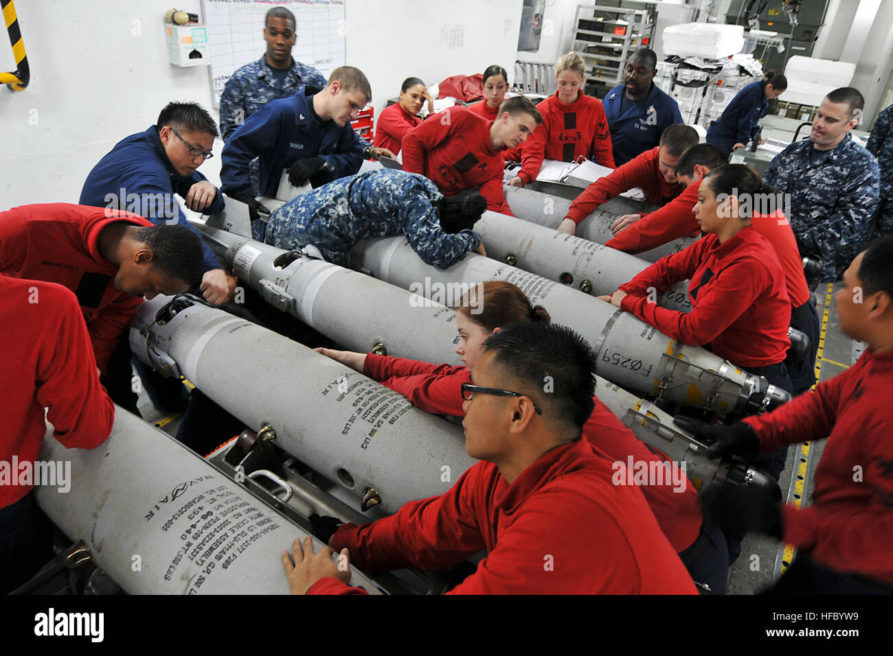 Aviation ordnanceman work together during a GBU-54 bomb assembly ...
