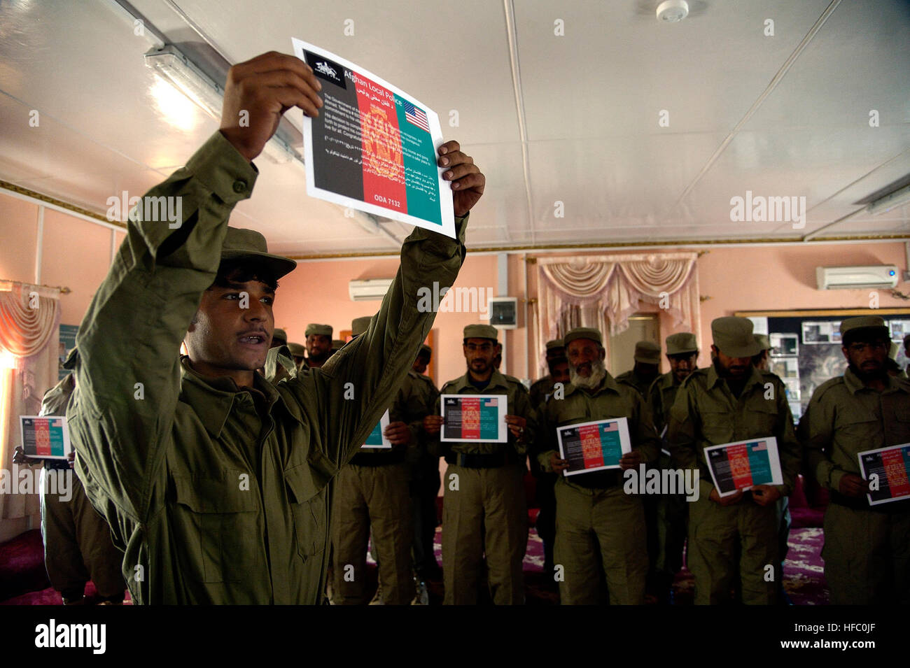 An Afghan Local Police (ALP) member shows off his certificate during a ...