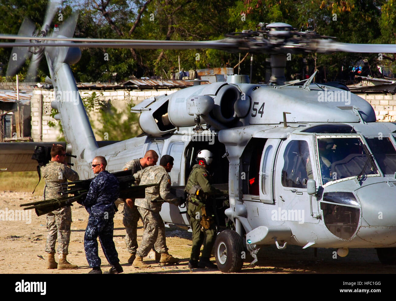 U.S. Navy Capt. Richard Sharpe helps U.S. Army Soldiers assigned to the ...