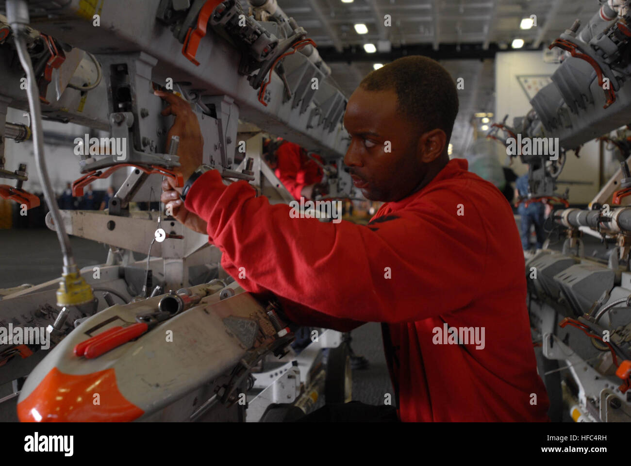 Aviation Ordinanceman 3rd Class Christopher Isaac, inspects a BRU-44 ...
