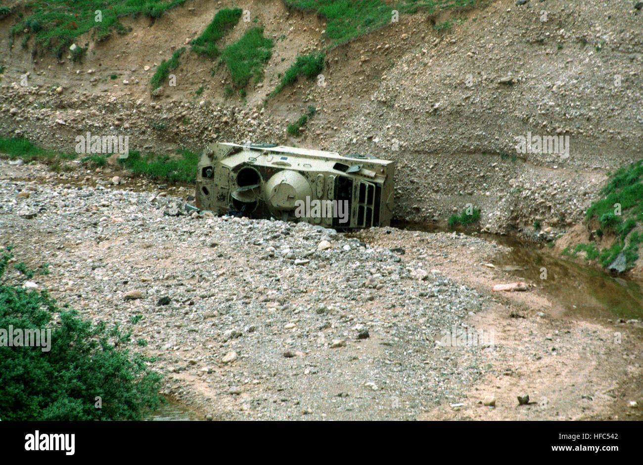 An Iraqi BRDM-2 scout car lies on its side in a ditch outside the city ...