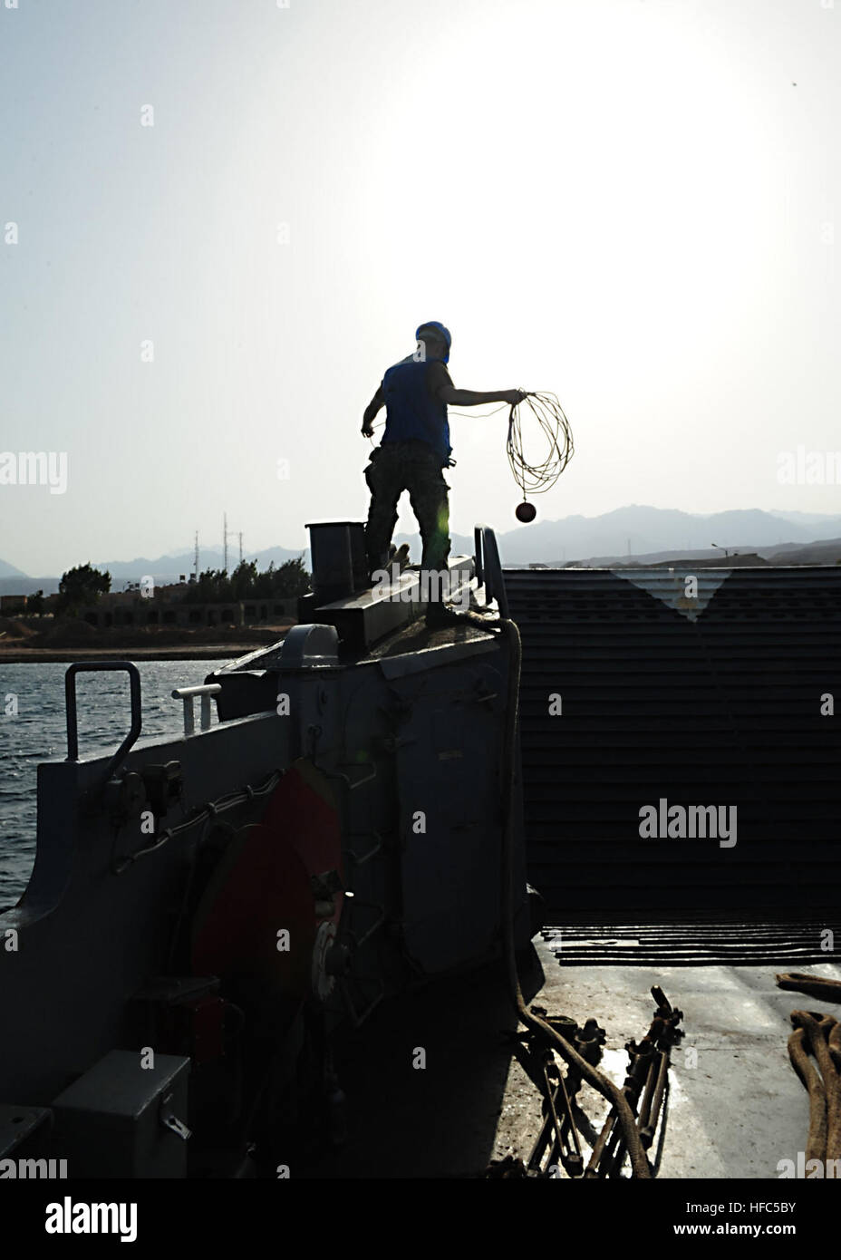 U.S. Navy Seaman Emmis Hunter prepares to toss a heaving line from ...