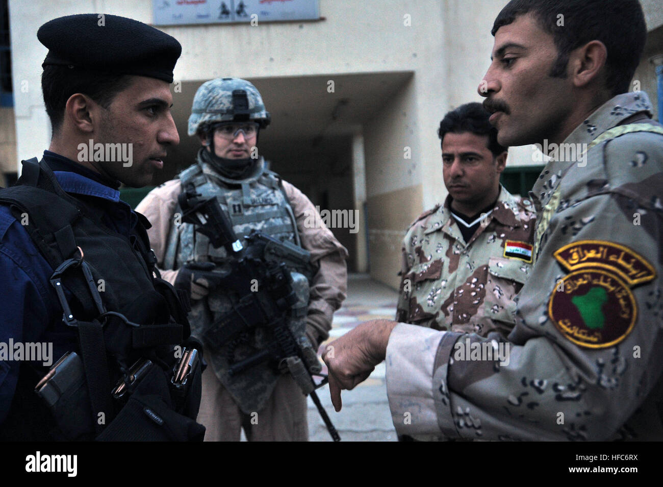 An Iraqi policeman speaks with a Sons of Iraq soldier during a walking ...