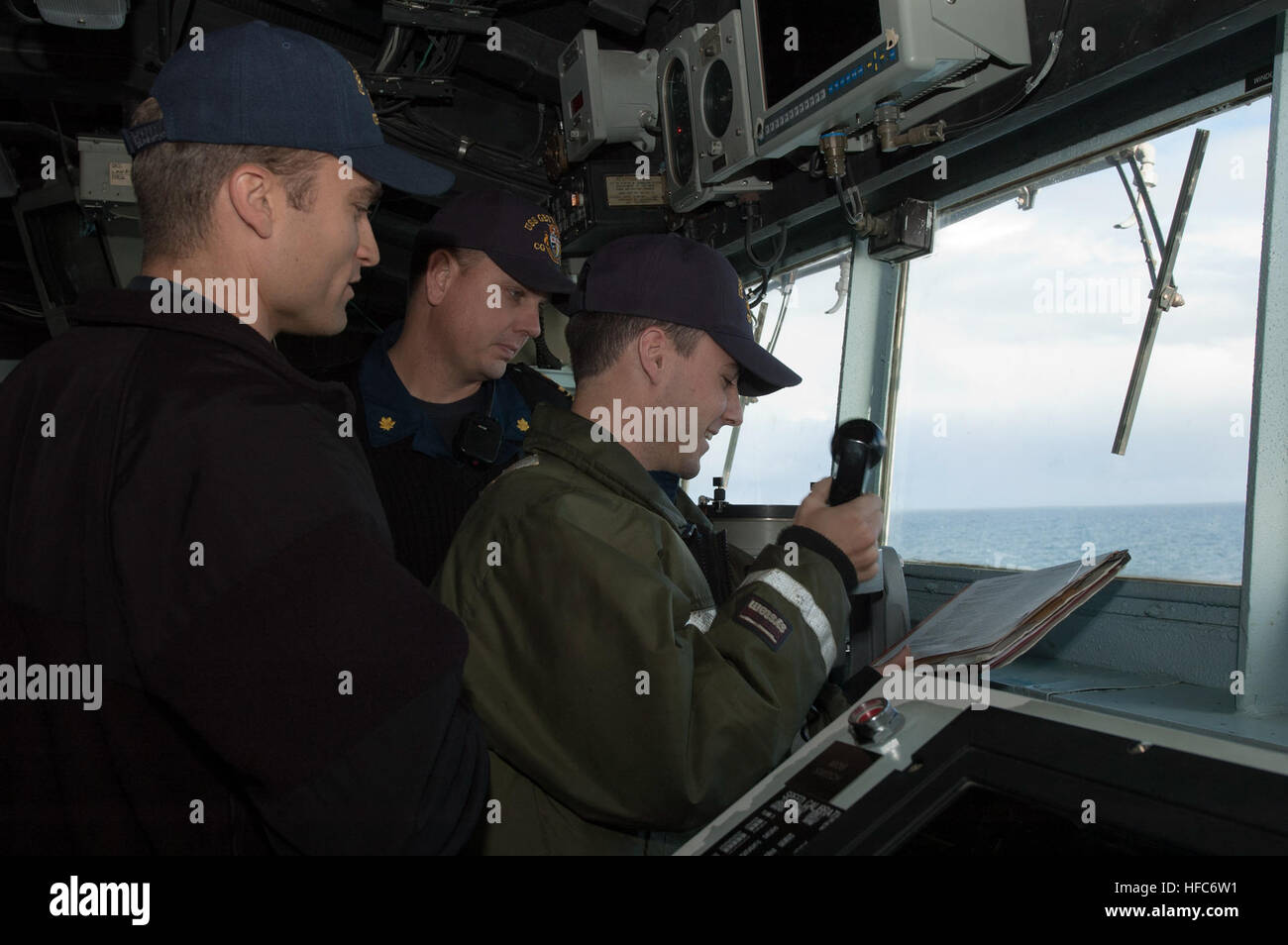 U.S. Navy Lt. Cmdr. John Rummel, center, and Ensign Barrett Roof, left ...