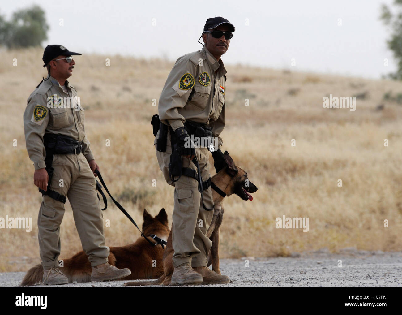 Iraqi dog handlers stand by as they wait for an instructor to evaluate ...