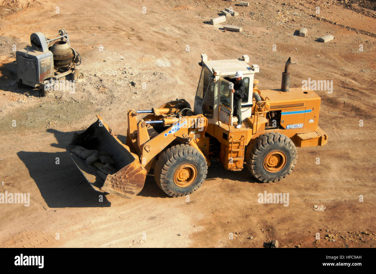 Iraqi workers move a bulldozer around the site of the new regional ...
