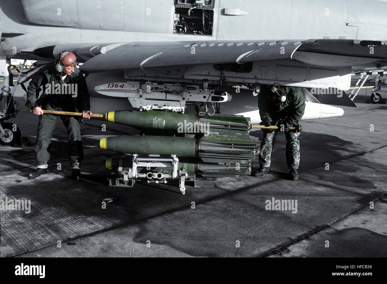 Crewmen load three Mark 81 general purpose high explosive bombs onto an ...