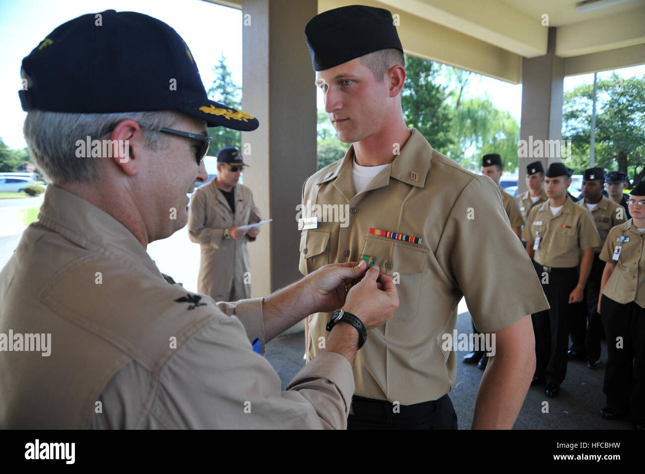 Capt. Eric Gardner, Commanding Officer of Naval Air Facility Atsugi, pins the Navy and Marine ...
