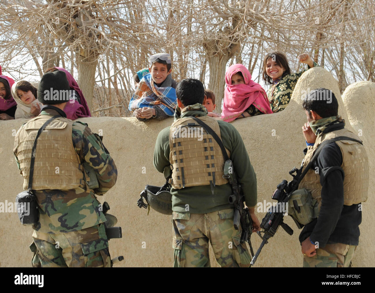 Members of the 8th Commando Kandak talk to children attending a medical ...