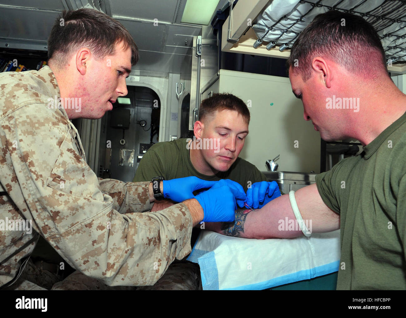 U.S. Navy Hospital Corpsman 3rd Class John Foran, left, assigned to the ...
