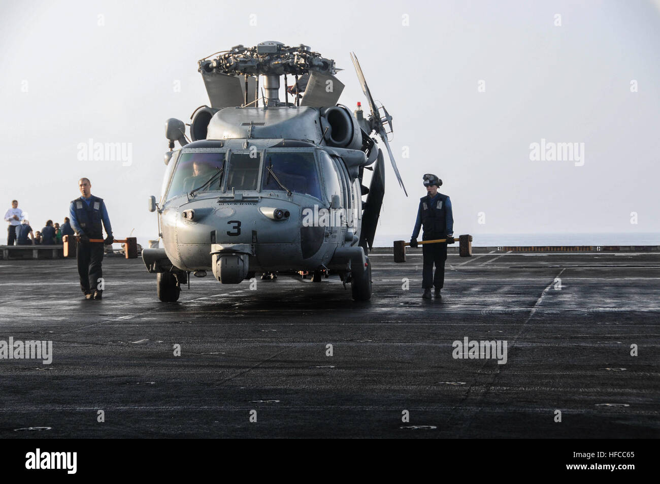 Sailors move an MH-60S Sea Hawk helicopter assigned to Helicopter Sea ...