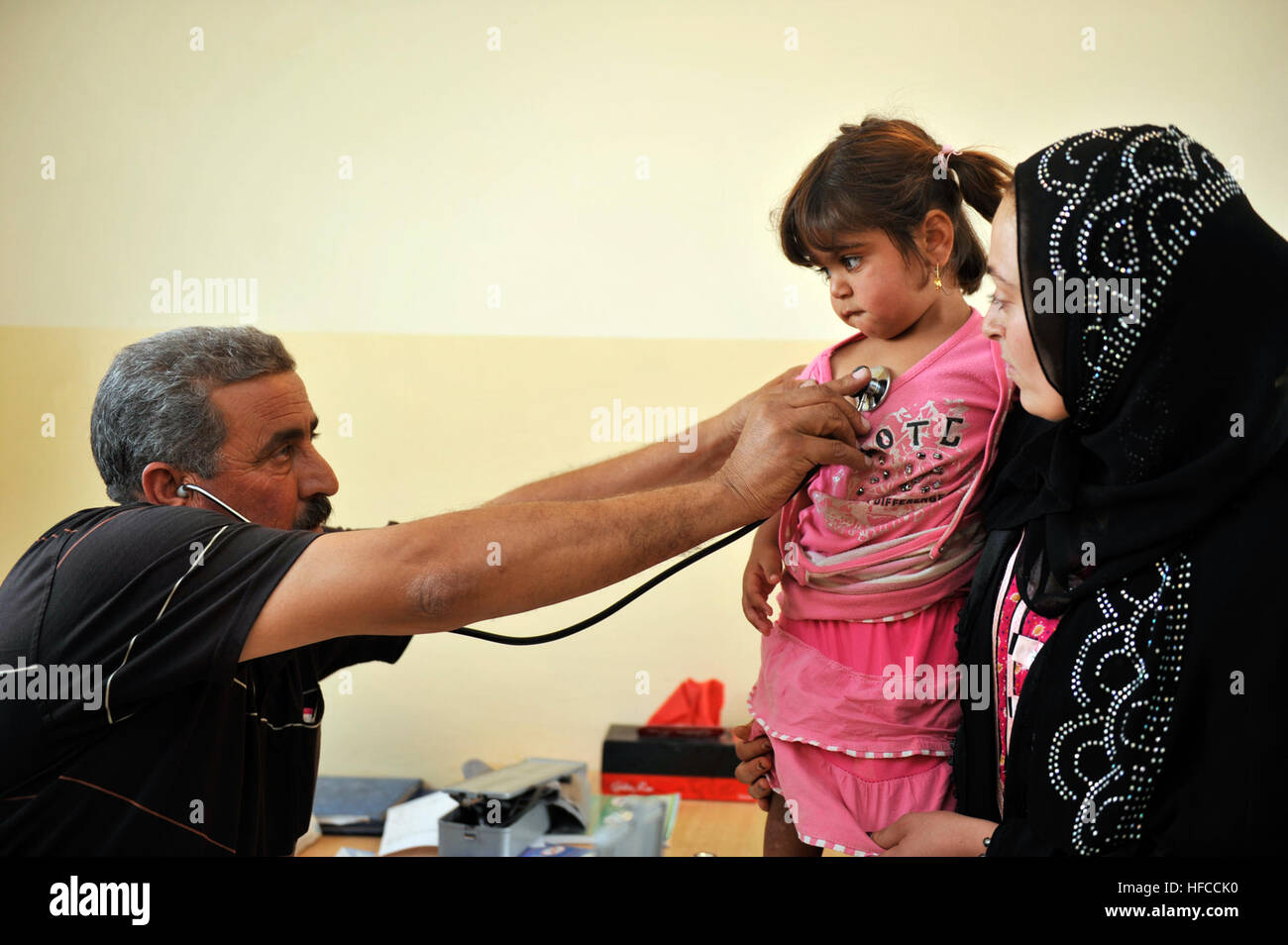 An Iraqi doctor examines an Iraqi child's heart rate during a Military ...