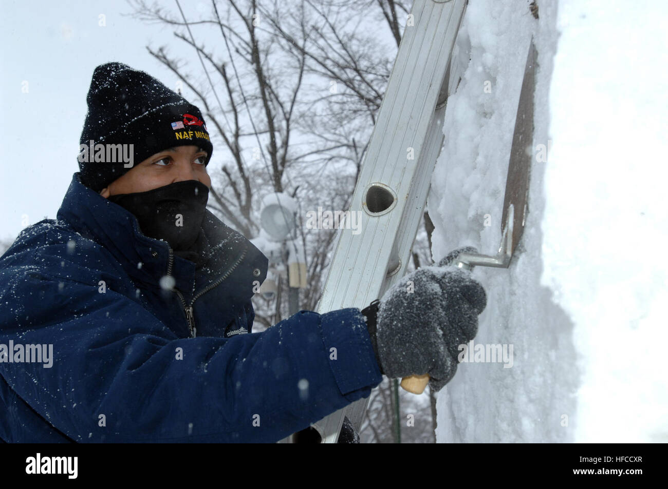With the help of a ladder, Petty Officer 2nd Class Tywan Ballard, an ...