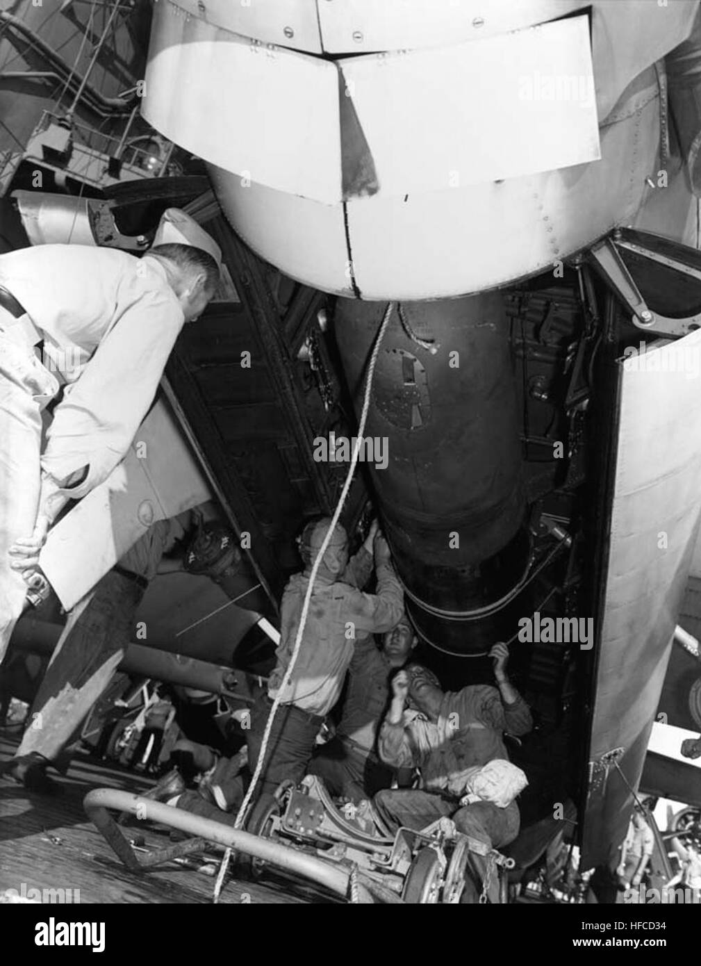 A Mark XIII torpedo is loaded into the bomb bay of a Grumman TBF-1 ...