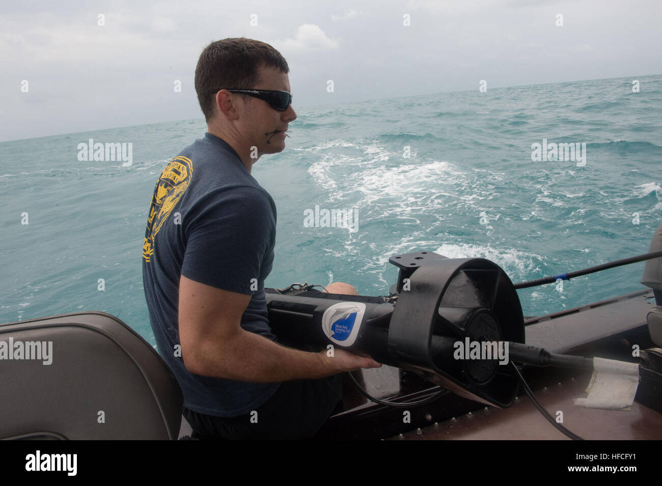 Navy Diver 2nd Class prepares to launch a Tow Fish side scan sonar ...