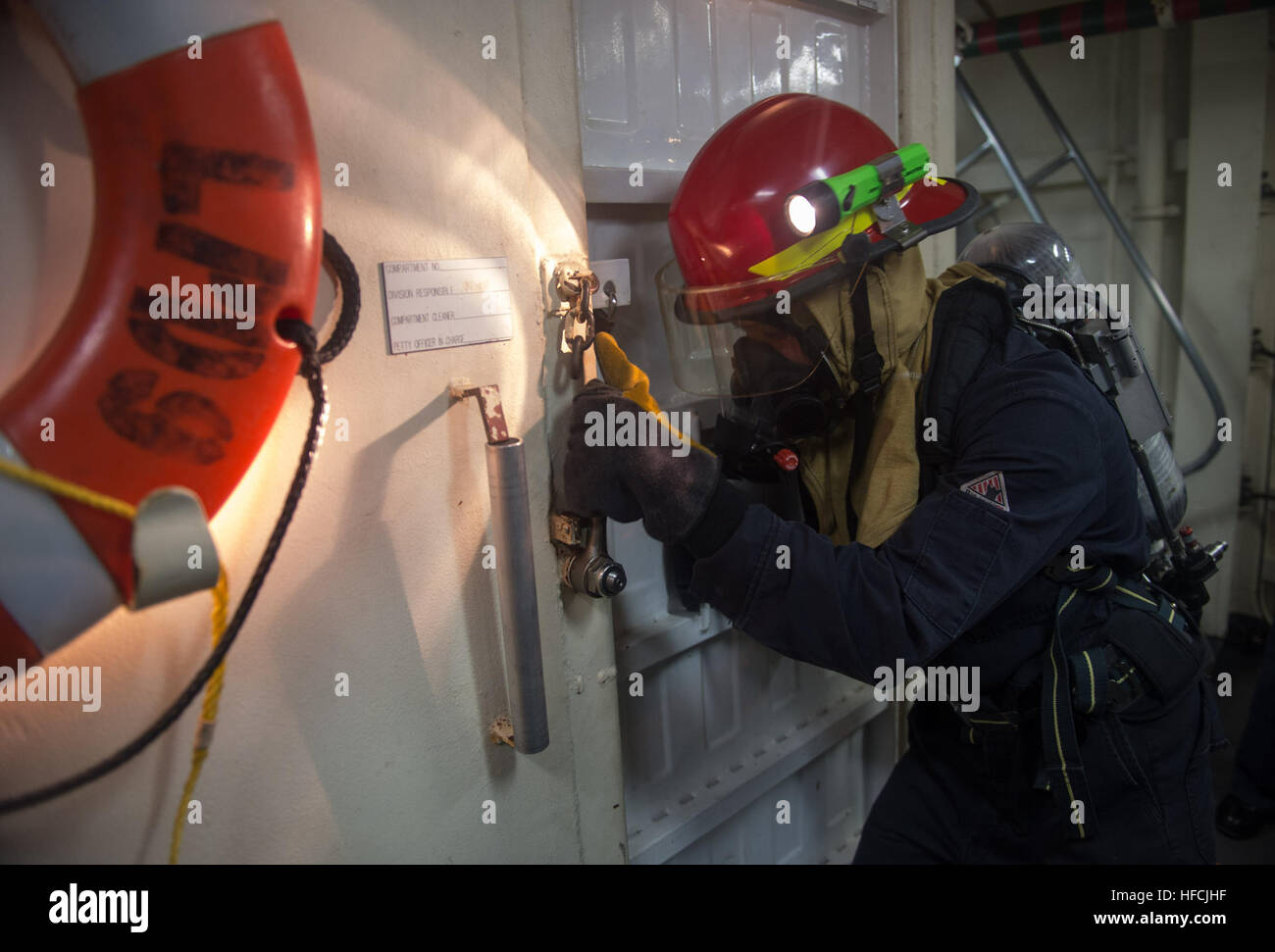 A hose team aboard the USS Denver (LPD 9) opens a space to combat a ...