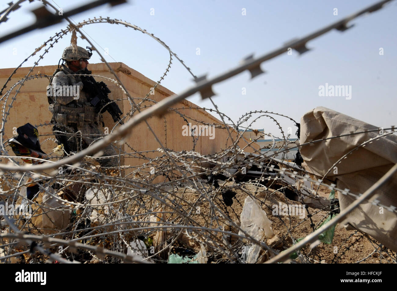 Framed in concertina wire, a U.S. Army Soldier assigned to Charlie ...