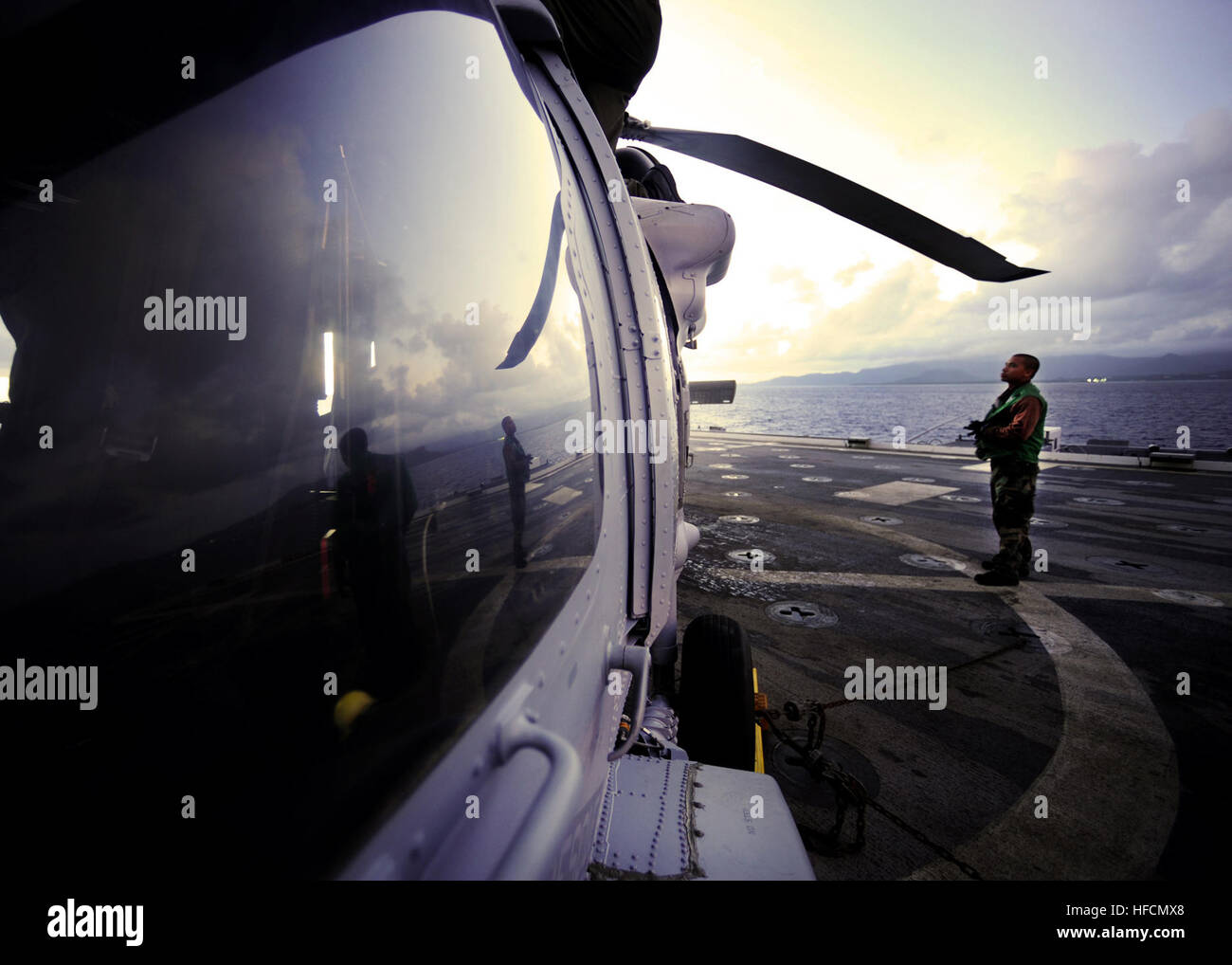 A sailor inspects an MH-60S Sea Hawk helicopter aboard USS Cleveland ...