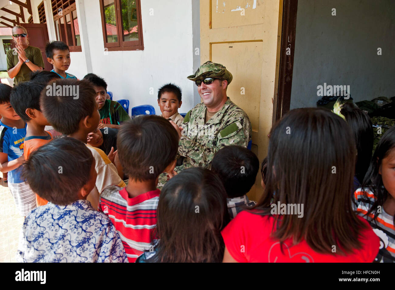 U.S. Navy Master-at-Arms 3rd Class Derrick Durham plays with children ...