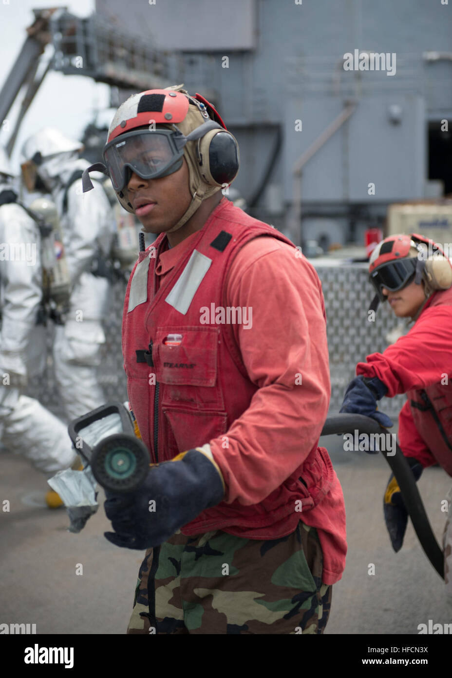 U.S. Navy Logistics Specialist Seaman Demetrius Richardson leads a hose ...