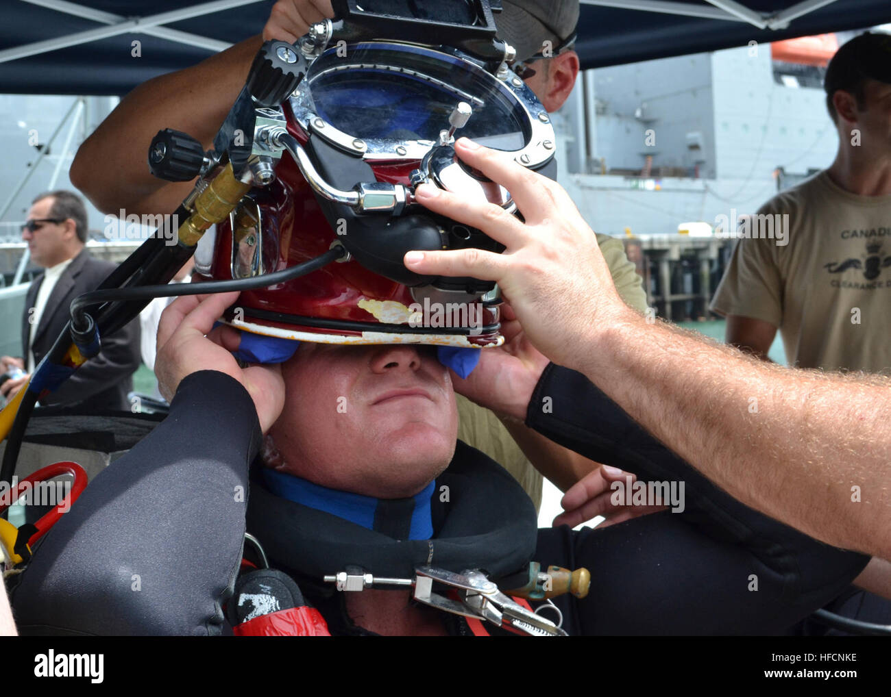 A Canadian diver with the combined Fleet Diving Unit dons a dive helmet ...