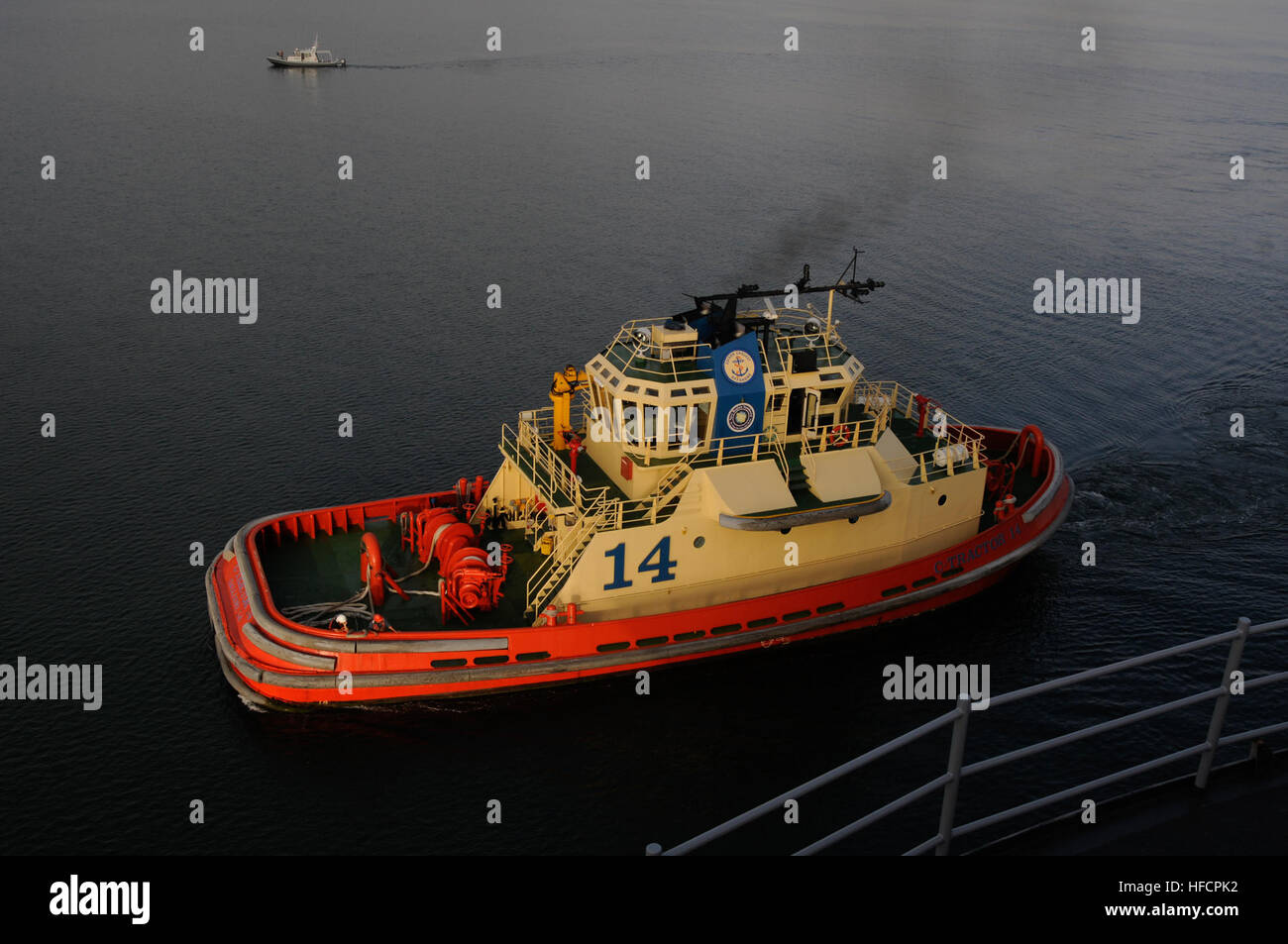 A sea tractor comes alongside as amphibious assault ship USS Peleliu ...