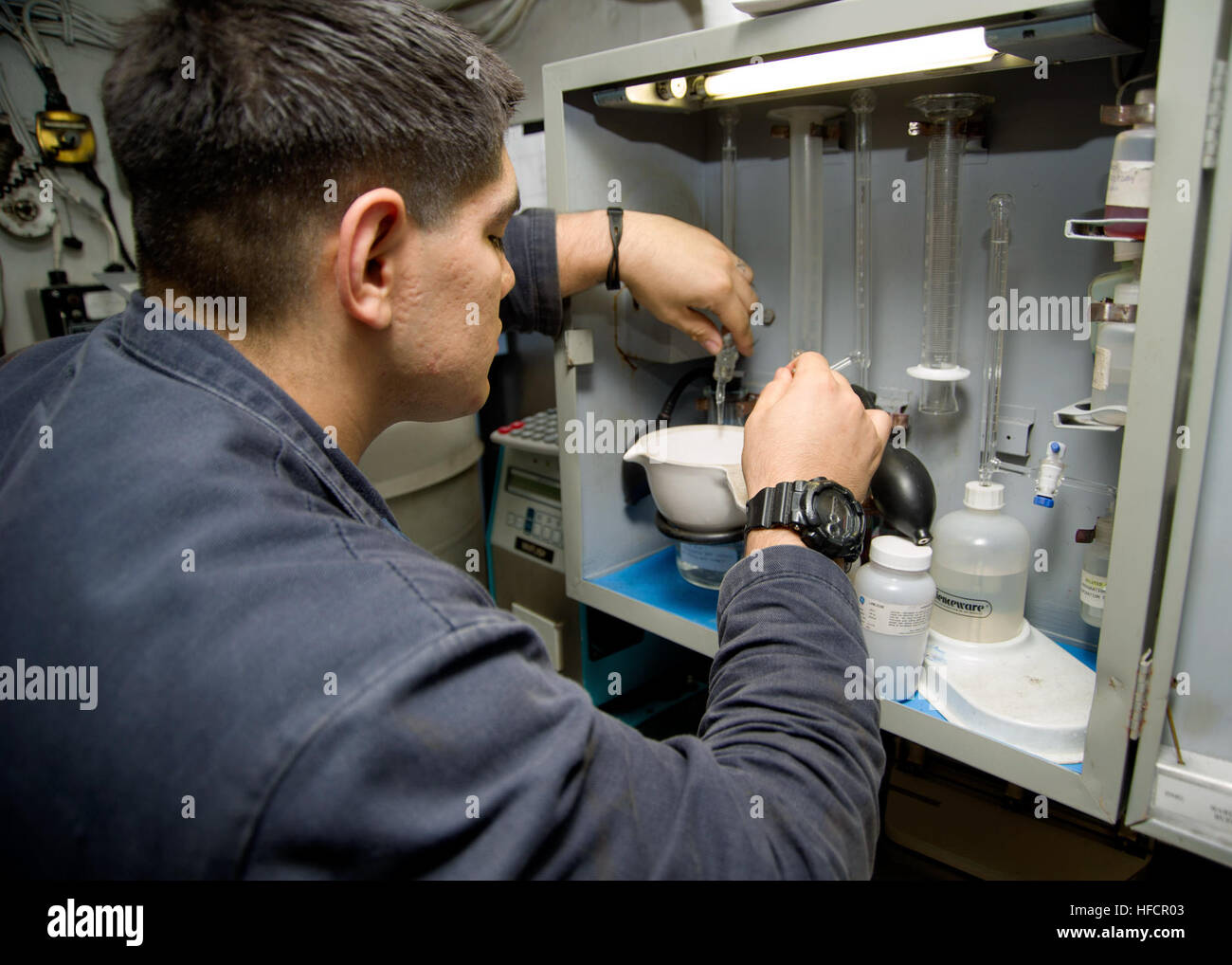 Machinist's Mate 2nd Class Thomas Mesenbrink tests a boiler water ...