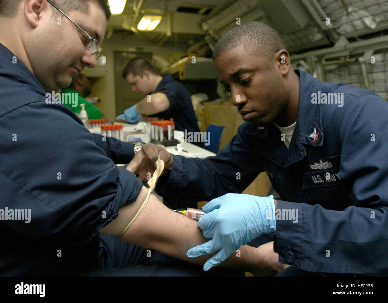 Petty Officer 3rd Class Michael Ousley, hospital corpsman, draws blood ...
